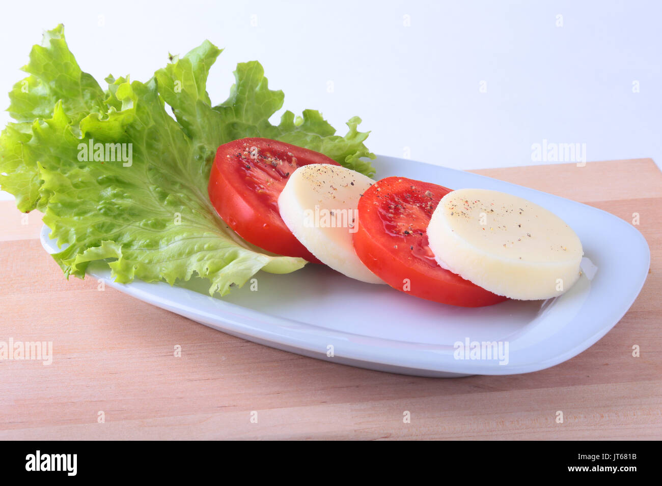 Portion of Mozzarella with Tomatoes, lettuce leaf and Balsamic dressing ...