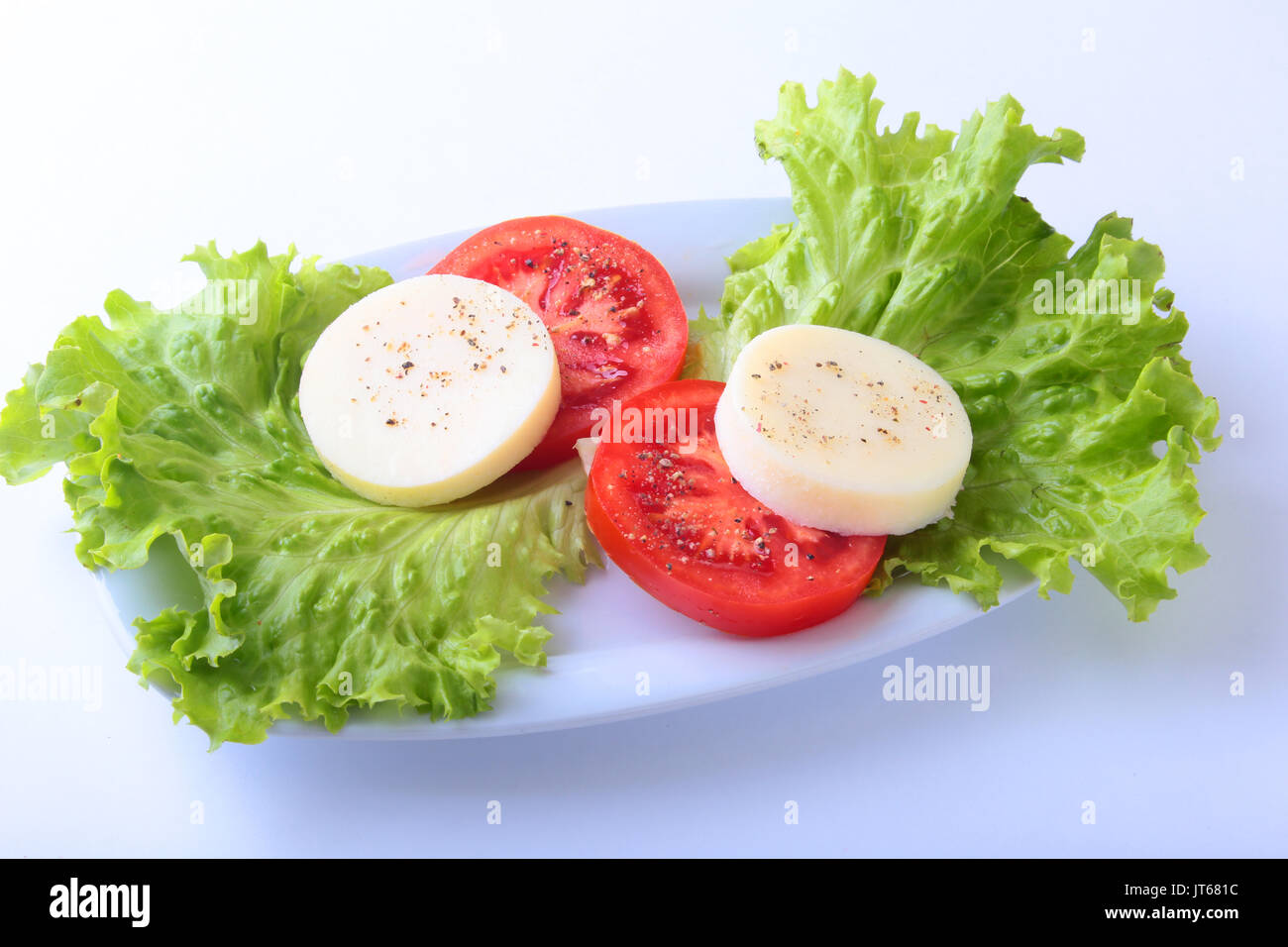 Portion of Mozzarella with Tomatoes, lettuce leaf and Balsamic dressing ...