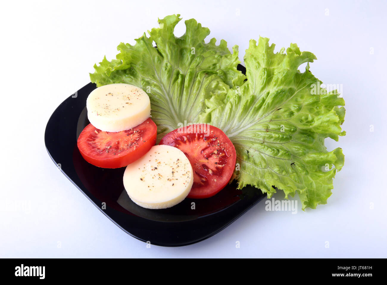 Portion of Mozzarella with Tomatoes, lettuce leaf and Balsamic dressing ...