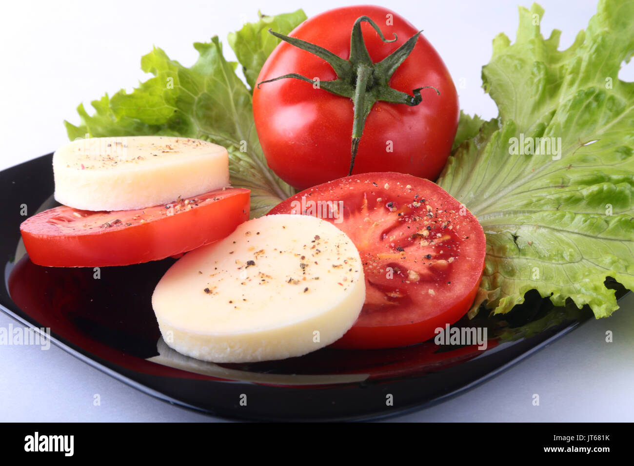 Portion of Mozzarella with Tomatoes, lettuce leaf and Balsamic dressing ...