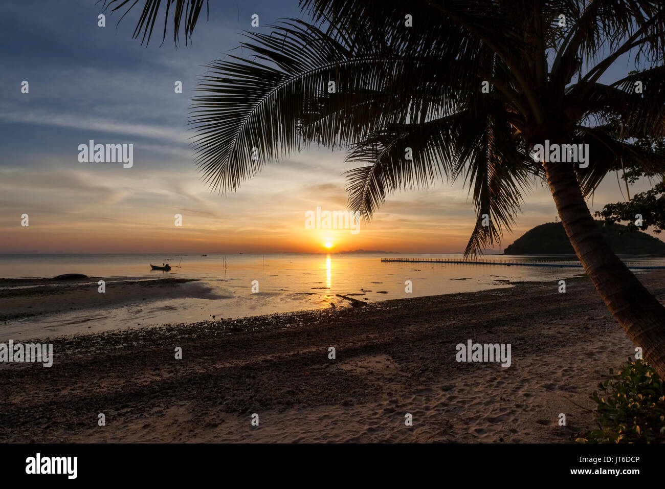 Palm tree silhouette during a colorful tropical sunset at Nathon beach ...