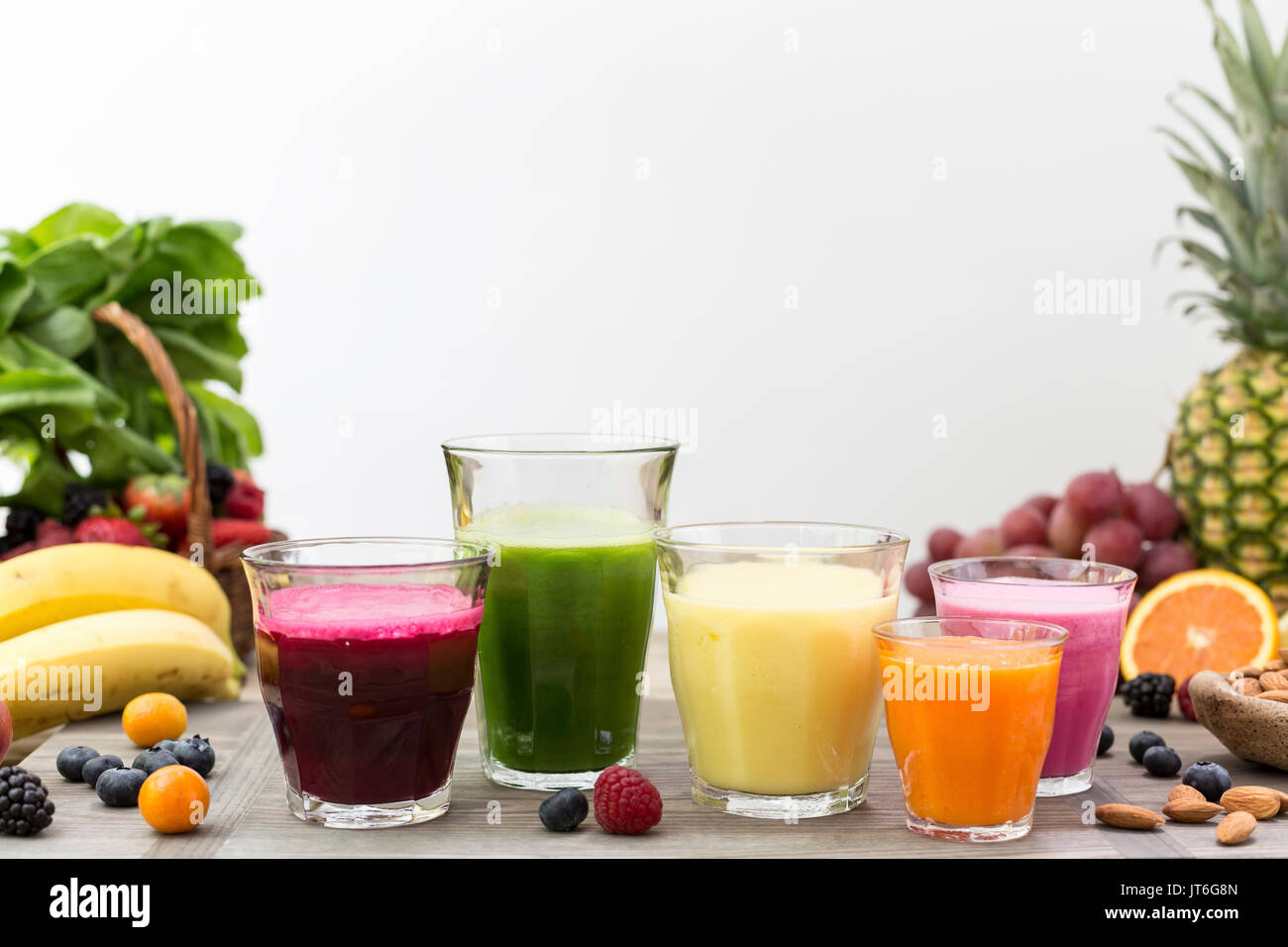 Five glasses of fresh smoothies (in all different colors) are ...