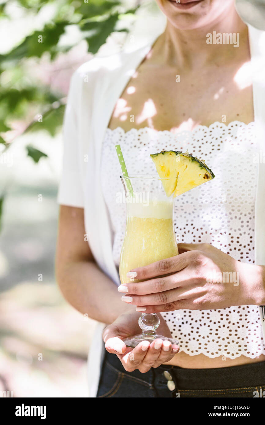 A woman holds a pina colada cocktail Stock Photo - Alamy