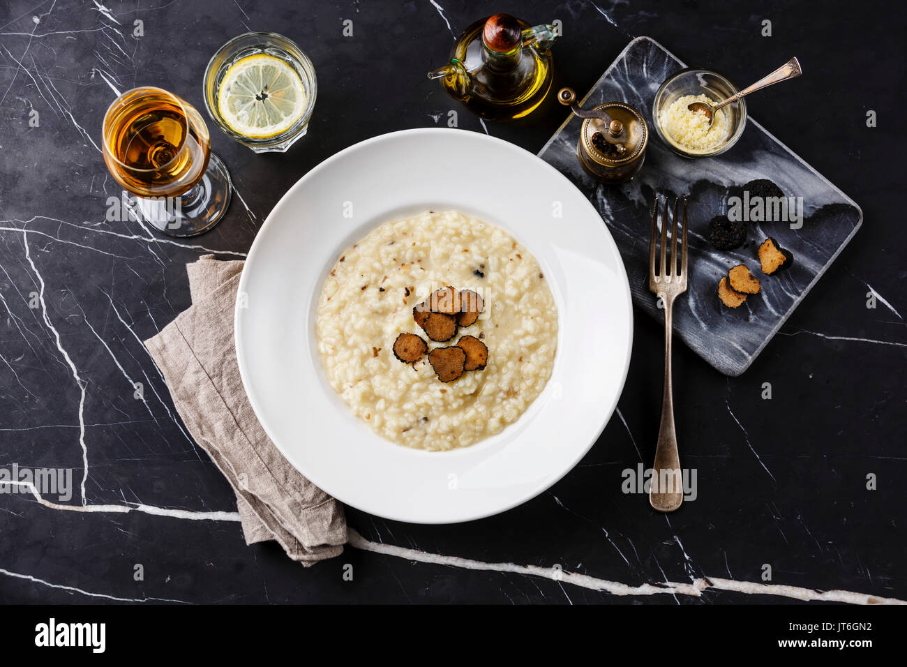 Risotto with black truffle on plate on dark marble table background ...