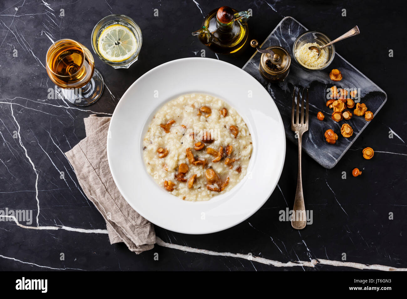 Risotto with chanterelle mushroom on plate on dark marble table ...