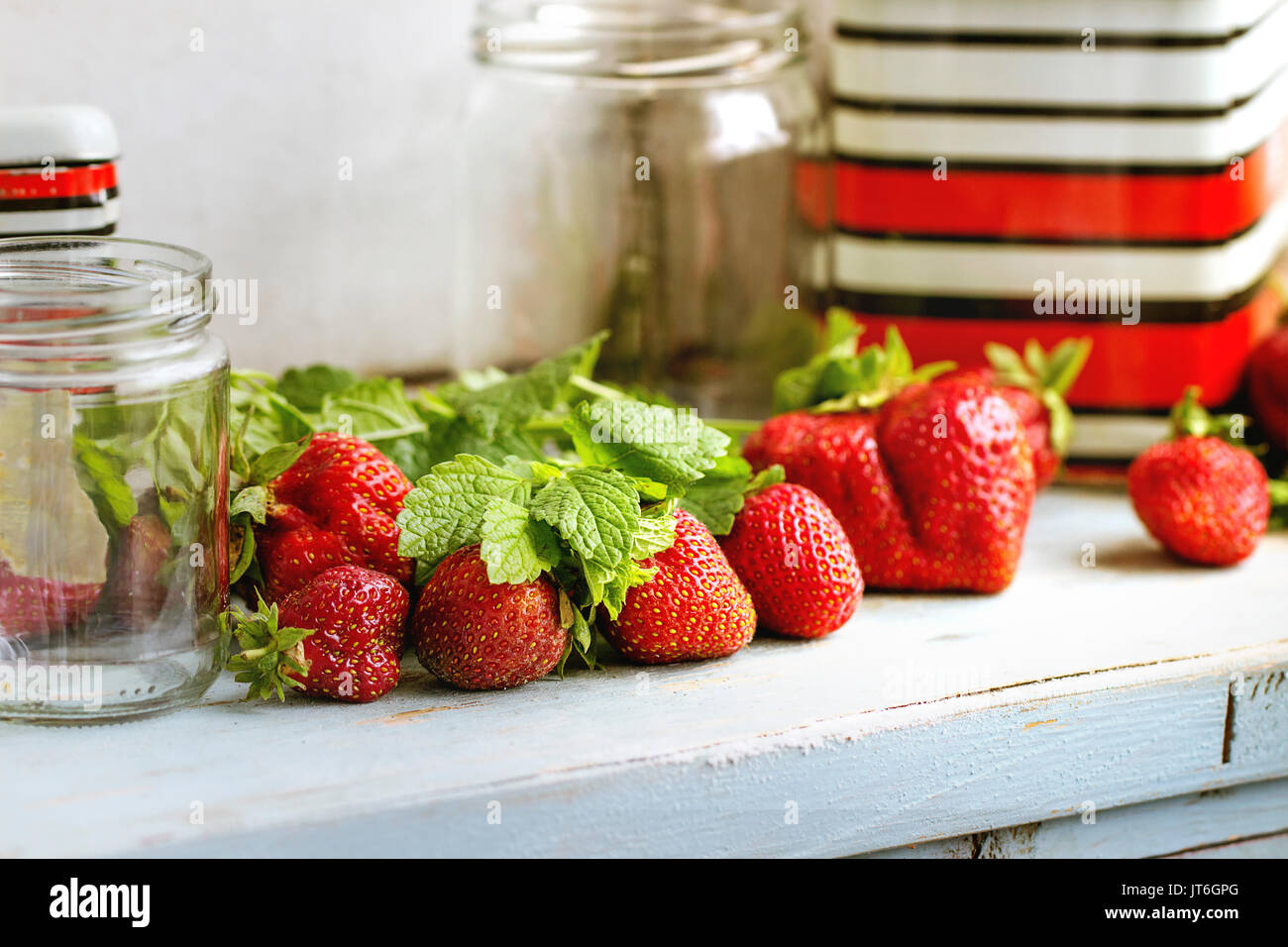 Fresh ripe garden strawberries and melissa herbs with empty glass and ...