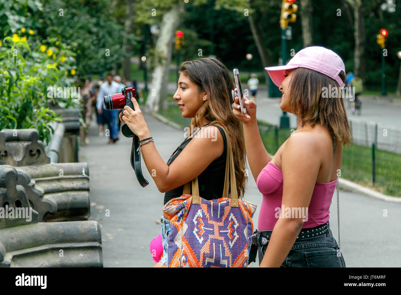 Two unidentified young ladies are taking pictures of a girl (not ...