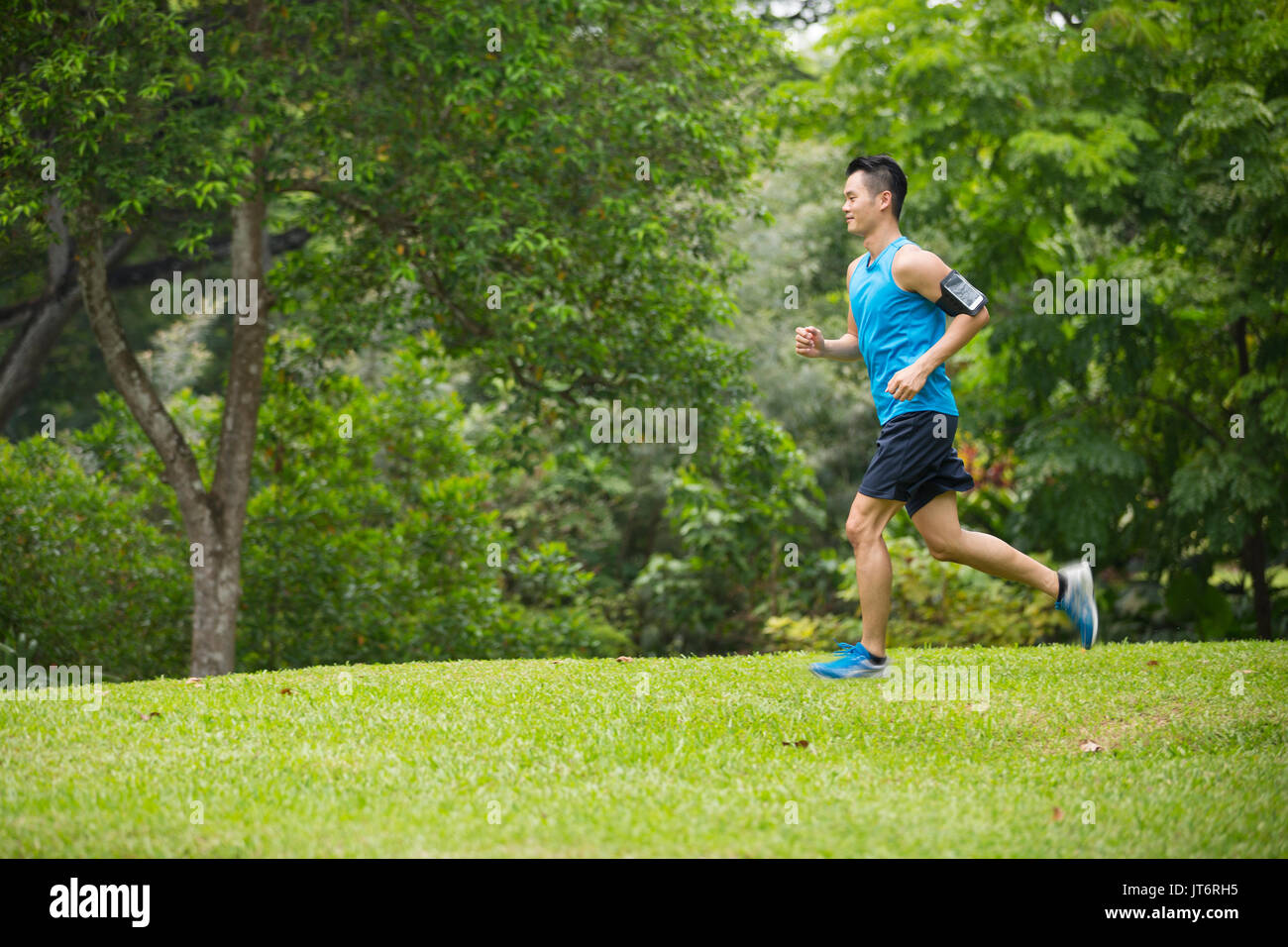 Athletic Asian man running outdoors. Action and healthy lifestyle ...