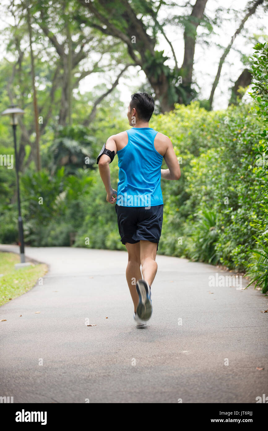 Athletic Asian man running outdoors. Action and healthy lifestyle ...