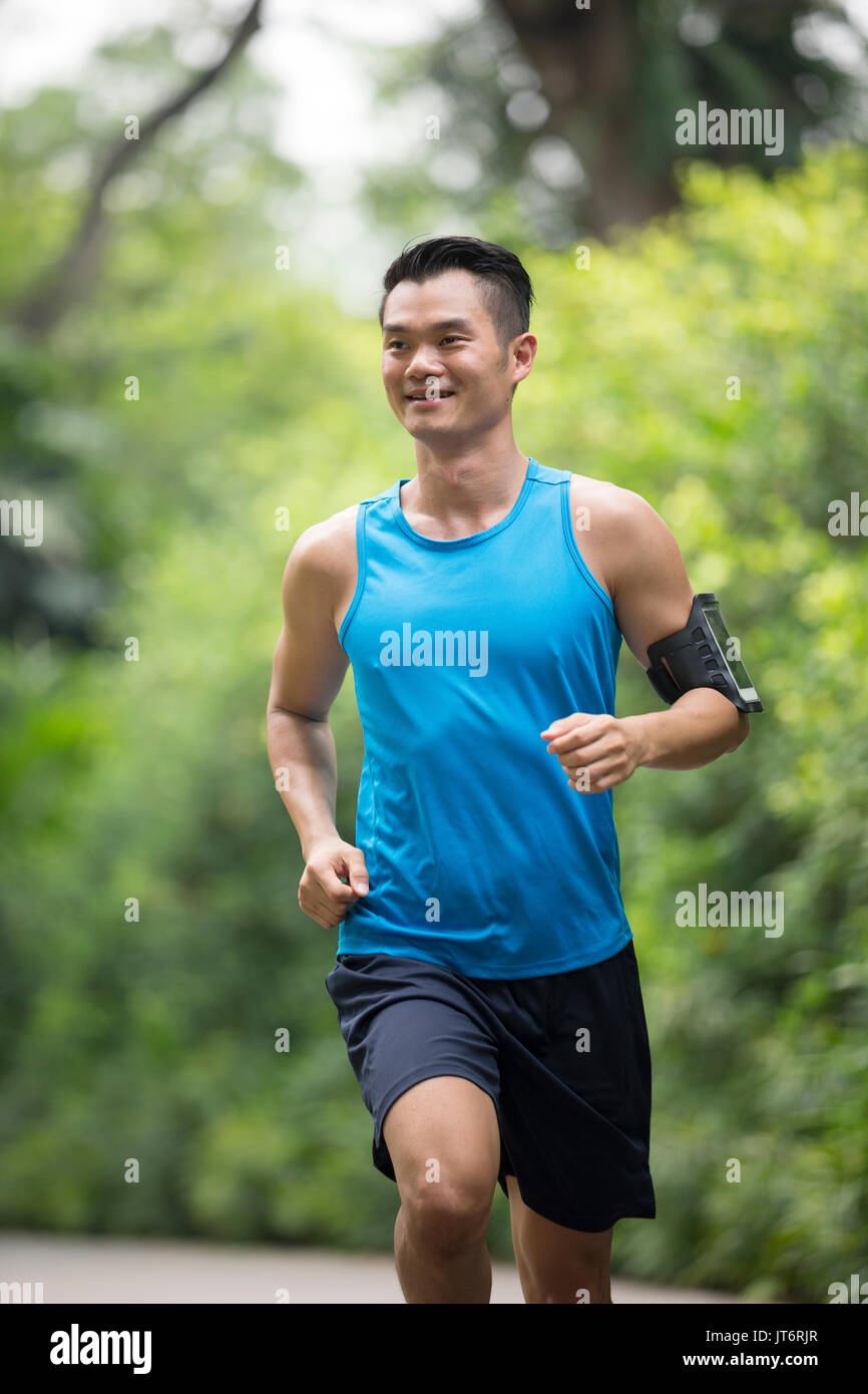 Athletic Asian man running outdoors. Action and healthy lifestyle ...