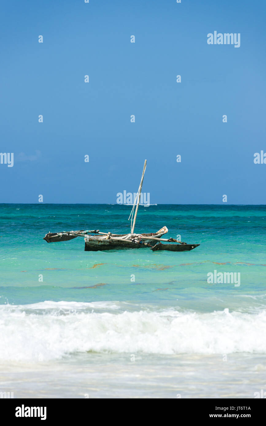 Traditional dhow wooden fishing boat anchored off shore, Diani beach ...
