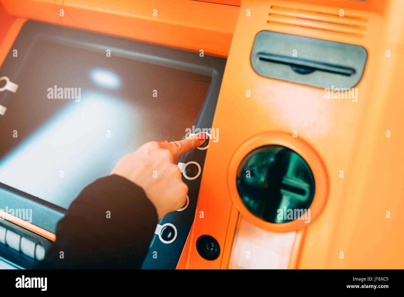 Woman getting money from an ATM. Choosing options Stock Photo - Alamy