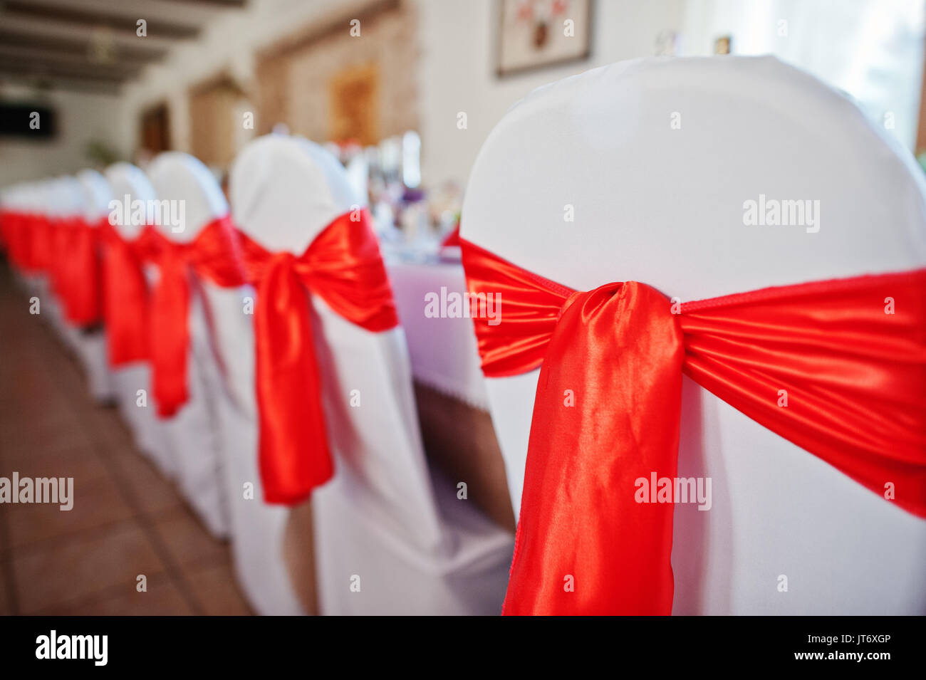 Gorgeously decorated chairs with red bows tied on them Stock Photo - Alamy