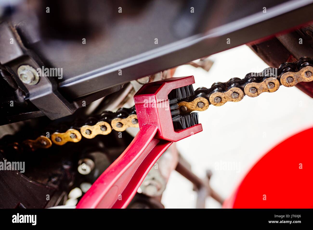 Cleaning motorcycle chain with dedicated chain brush Stock Photo - Alamy