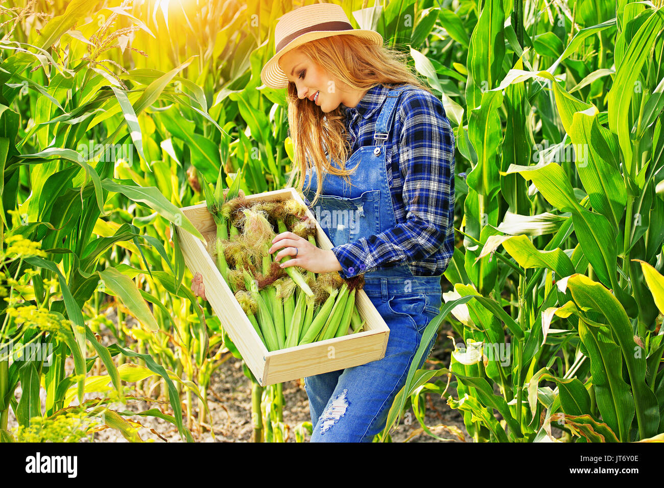 Happy farmer. Portrait of young and attractive red haired girl in hat ...