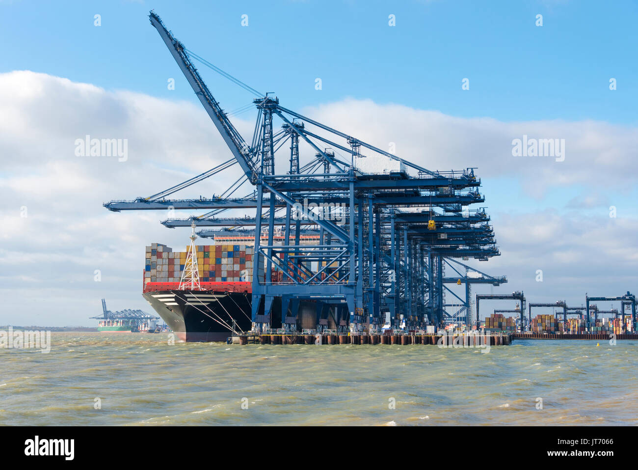 A large container ship unloads its cargo at a containor port Stock ...