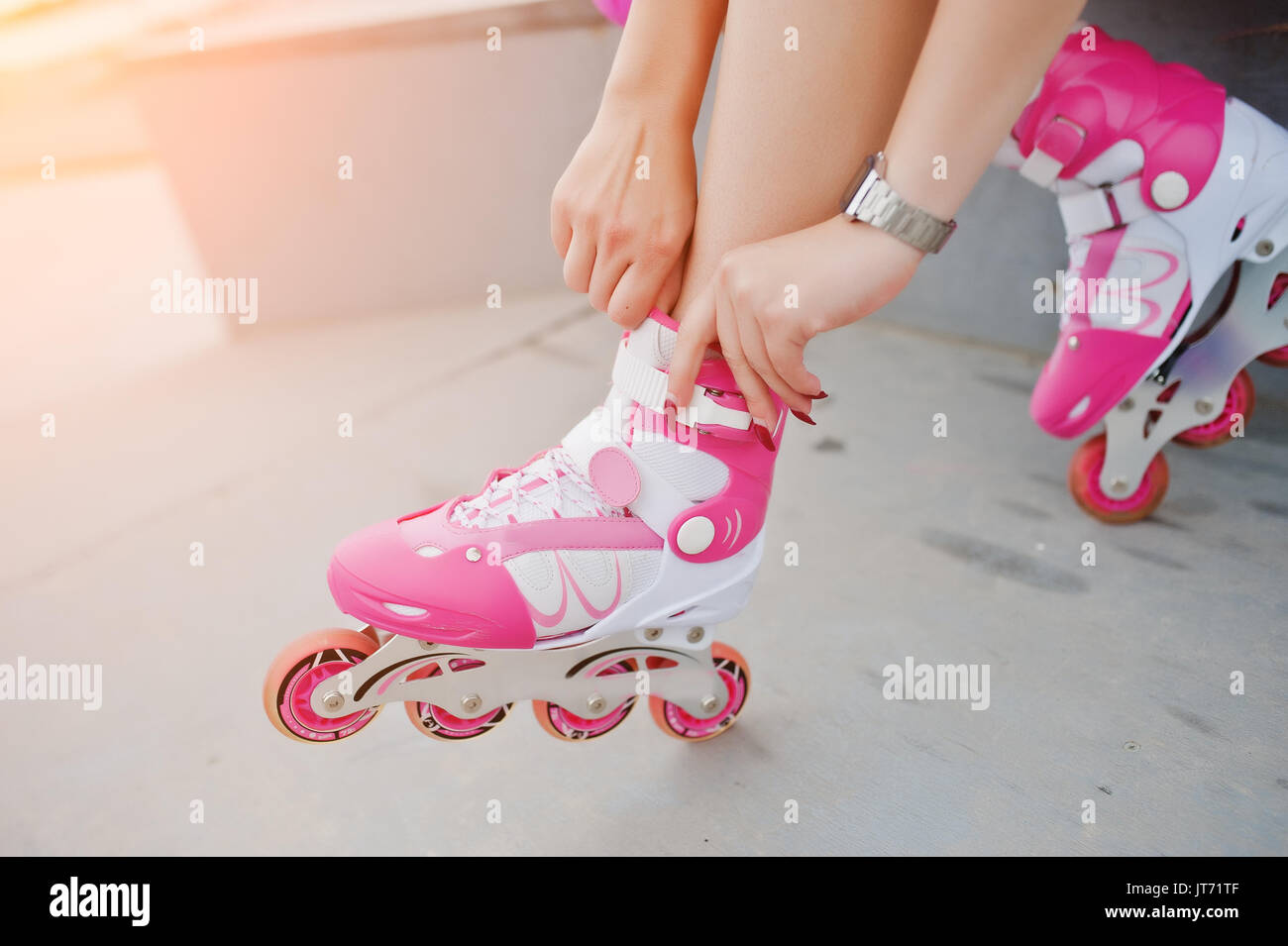 Young woman putting on rollerblades outdoor Stock Photo - Alamy