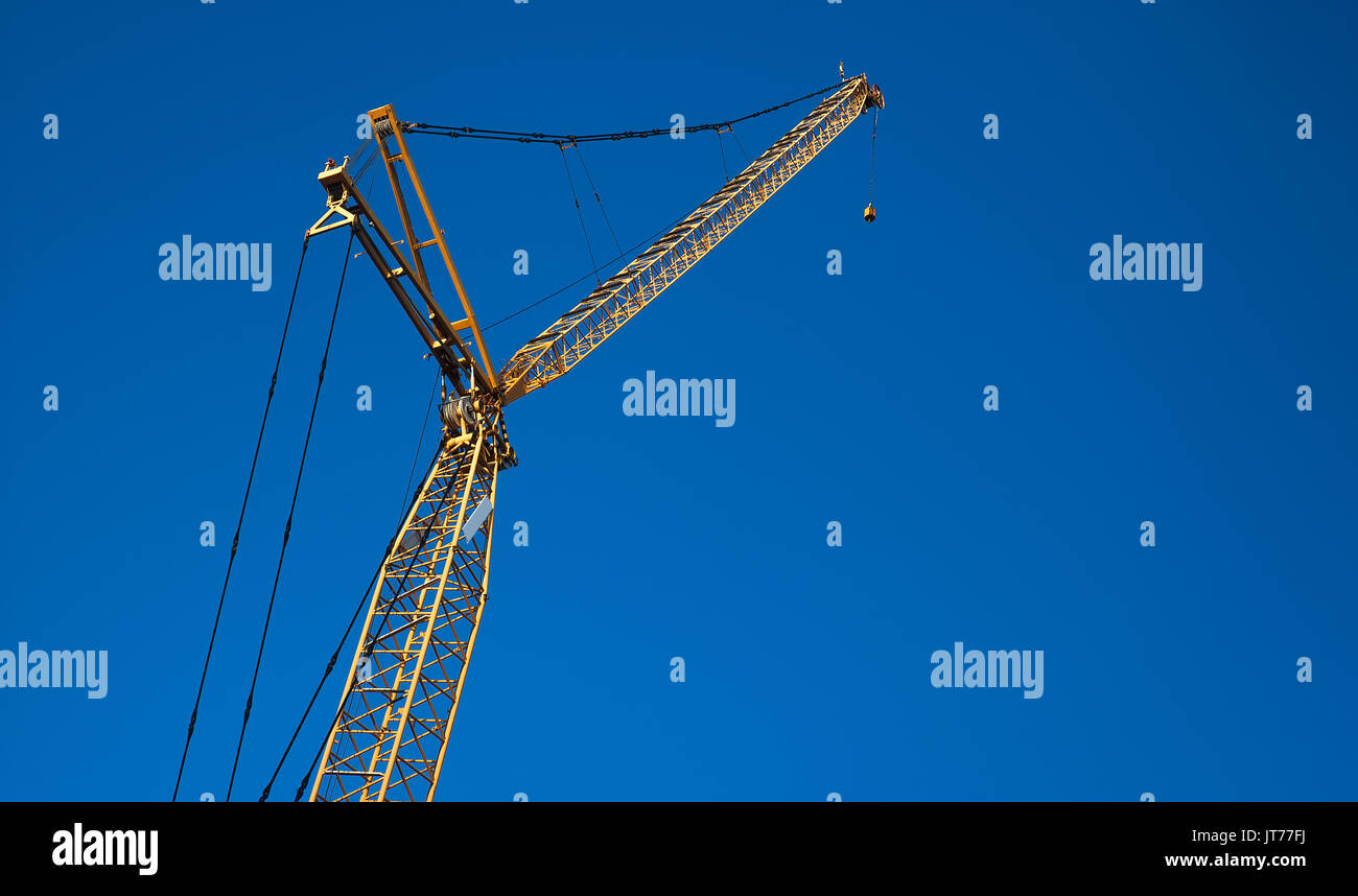 Cranes on site with boom high in sky Stock Photo - Alamy