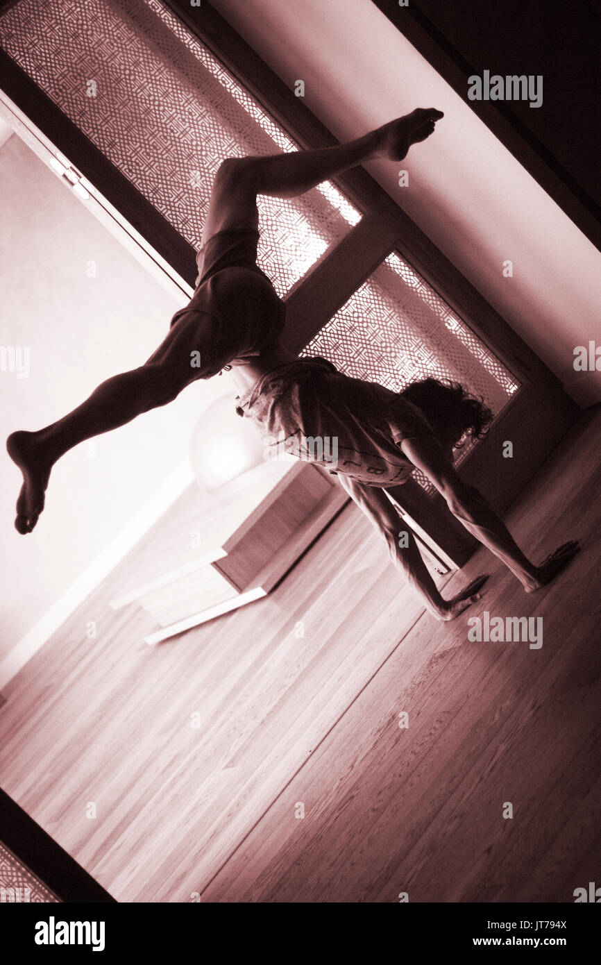 Male yoga teacher doing handstand inversion alisthenics and yoga asana ...