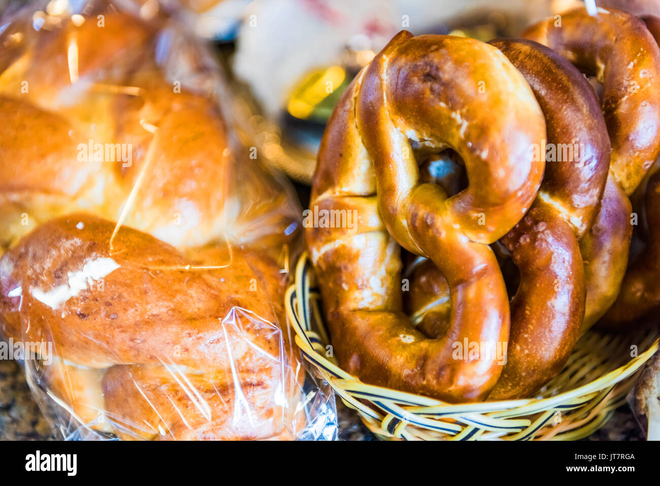 Closeup of fresh baked pretzels and challah bread in bakery baskets ...
