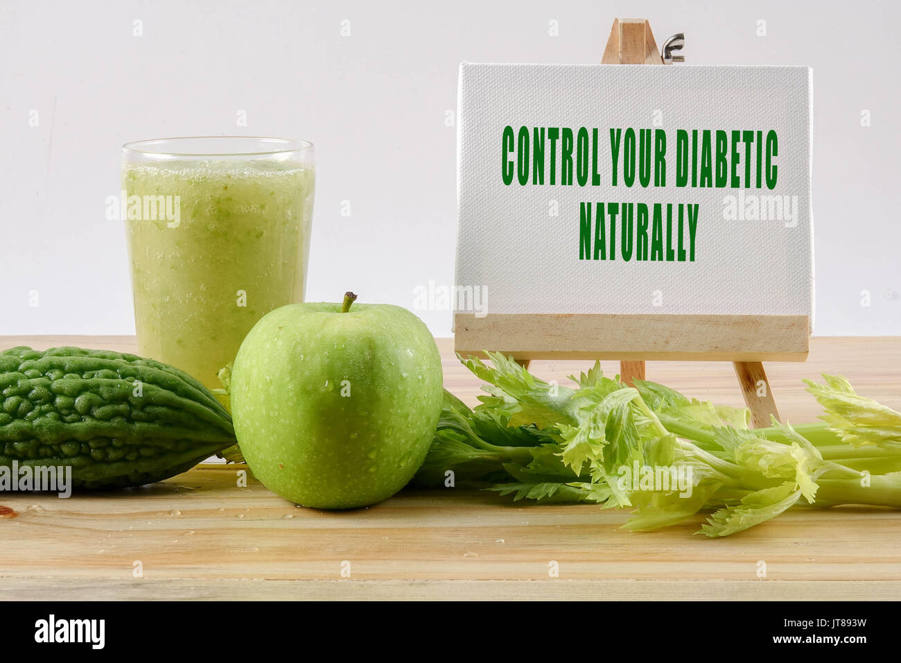 Green apple, bitter gout and celery isolated on wooden background to ...