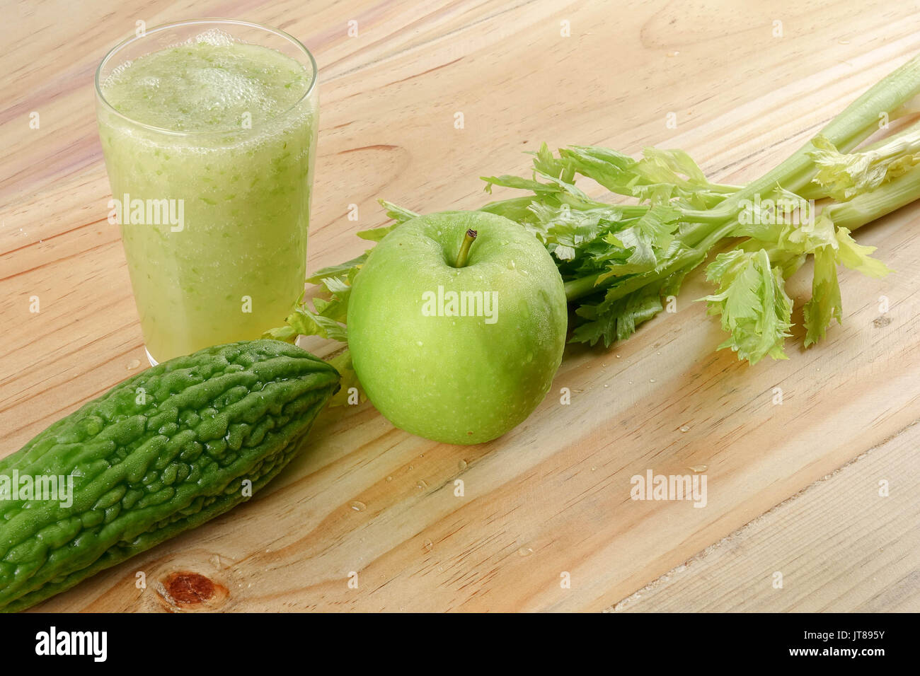 Green apple, bitter gout and celery isolated on wooden background to ...
