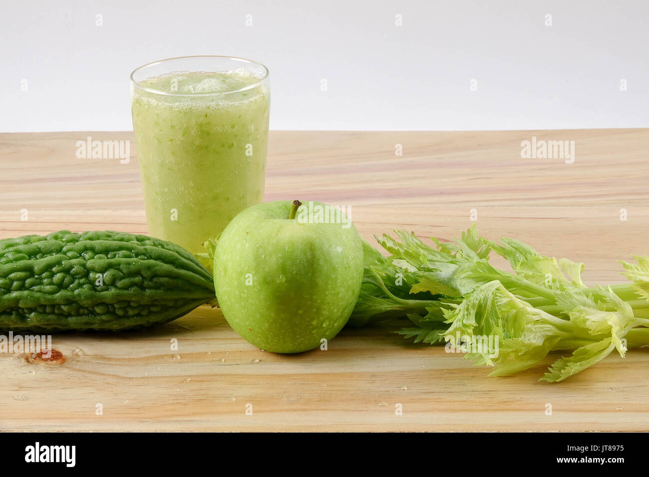 Green apple, bitter gout and celery isolated on wooden background to ...