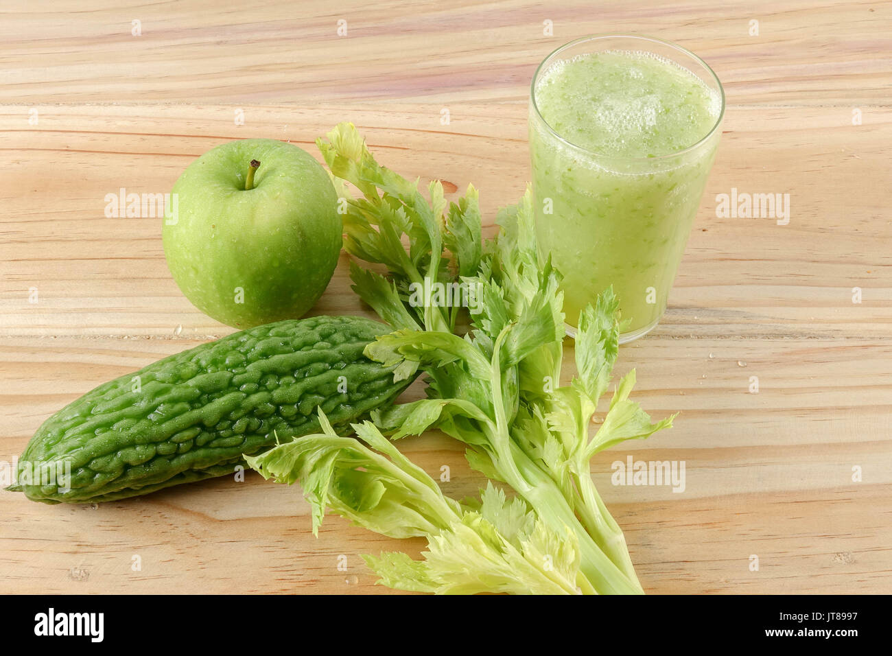 Green apple, bitter gout and celery isolated on wooden background to ...