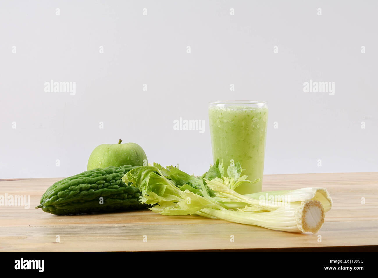 Green apple, bitter gout and celery isolated on wooden background to ...