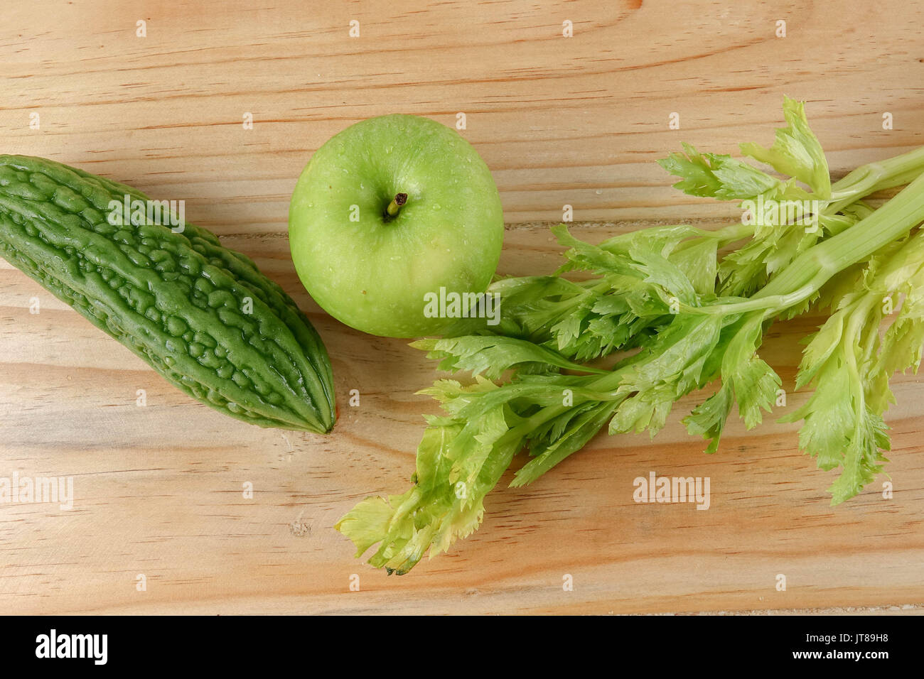 Green apple, bitter gout and celery isolated on wooden background to ...