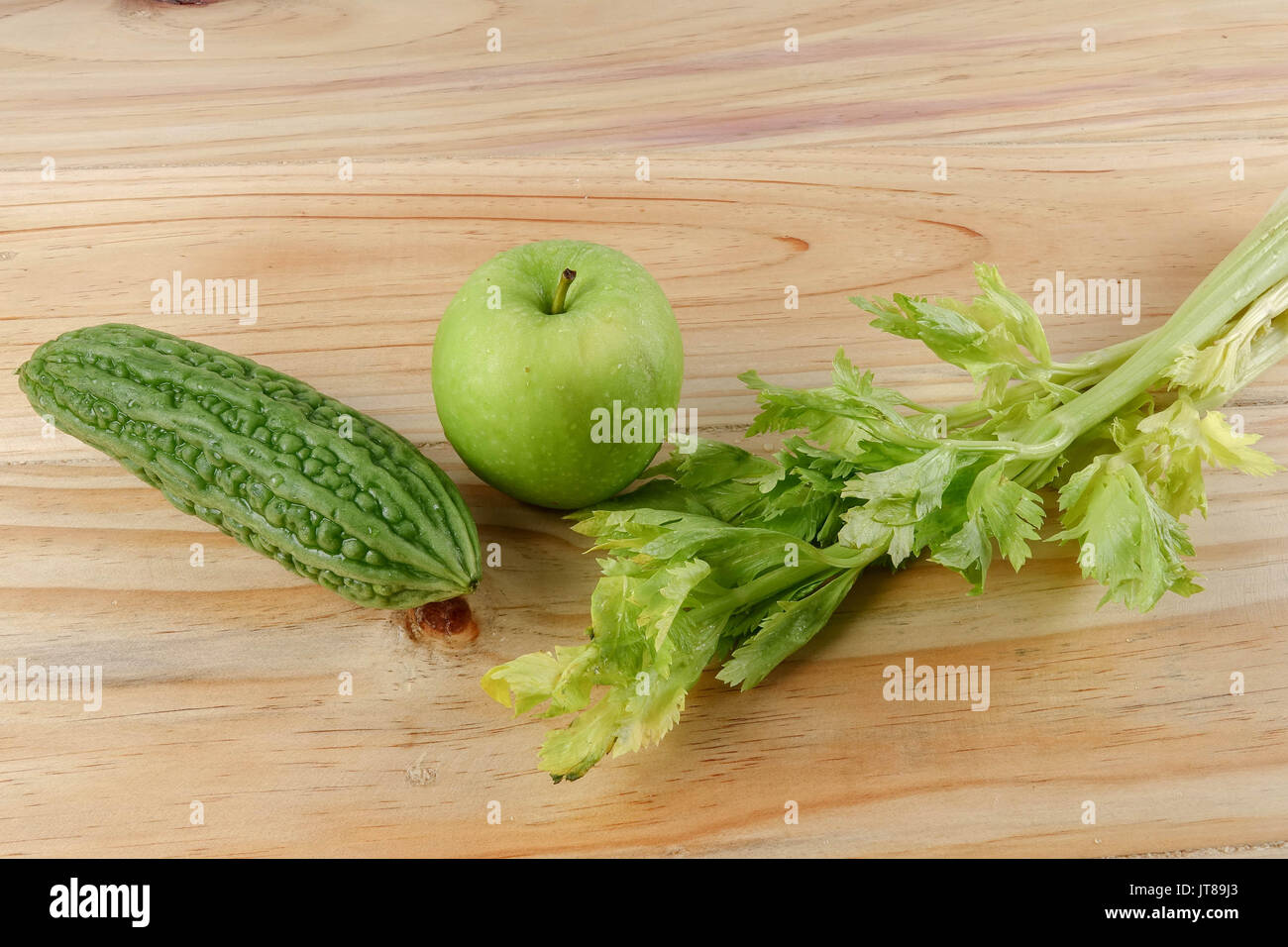 Green apple, bitter gout and celery isolated on wooden background to ...