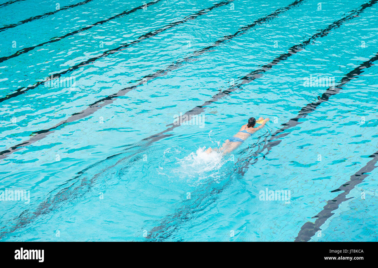 A woman swimming at the Freibad Aschberg open air pool, in couldy ...