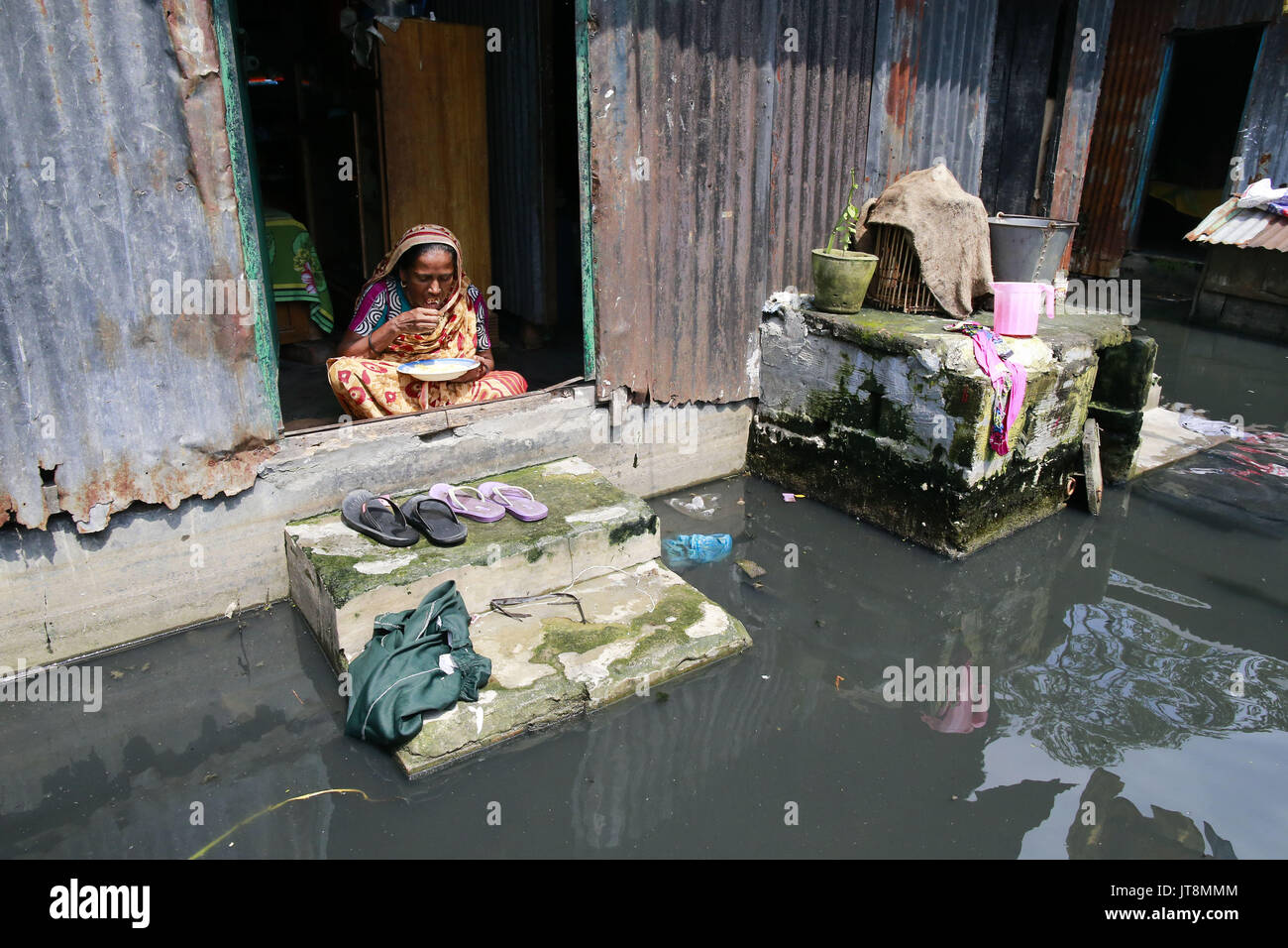 Dhaka, Bangladesh. 8th Aug, 2017. A Bangladeshi woman takes her lunch inside of her flooded ...