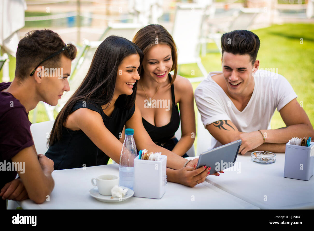 Young people sitting at table having fun Stock Photo - Alamy