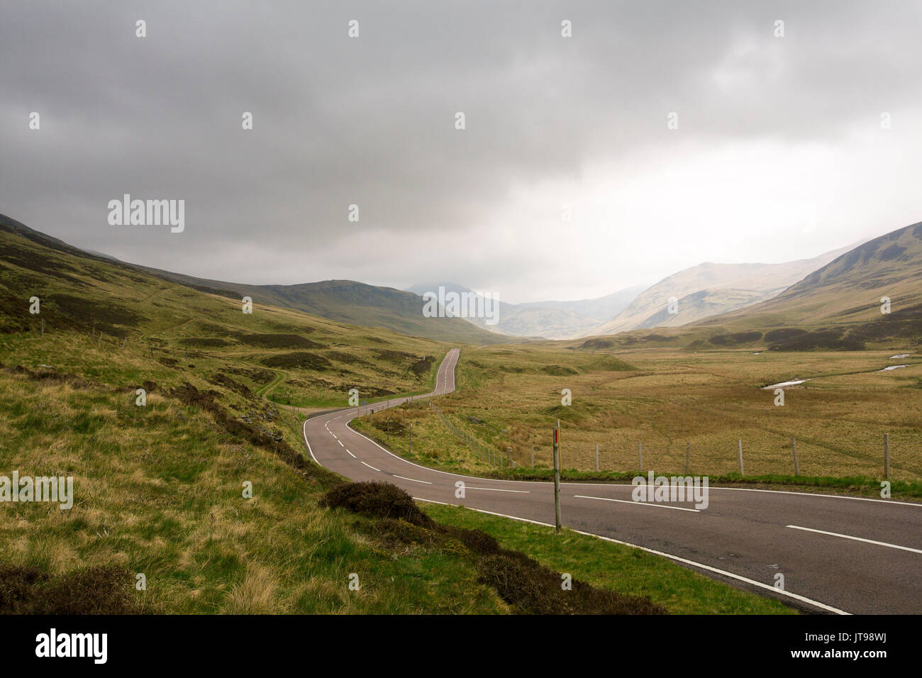 Road slicing through vast treeless mountain landscape of Cairngorms ...