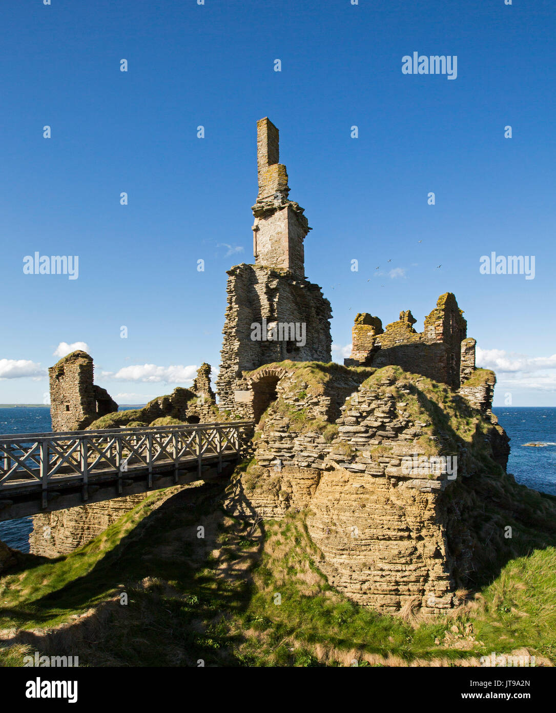 Ruins of Sinclair Girnigoe castle on clifftop with background of blue ...