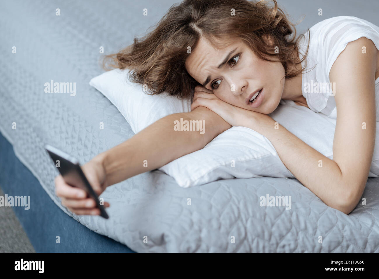 Unhappy surprised woman reading a message Stock Photo - Alamy
