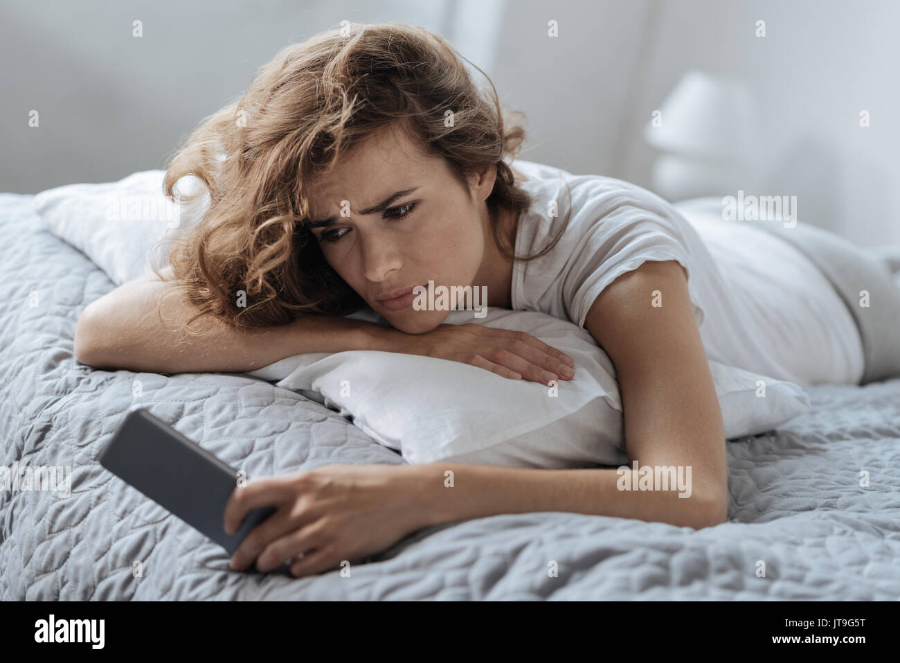 Sad cheerless woman checking her messages Stock Photo - Alamy