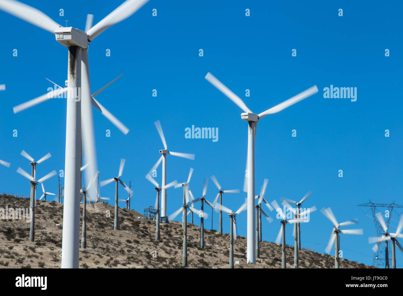 Wind turbine with power grid towers Stock Photo - Alamy