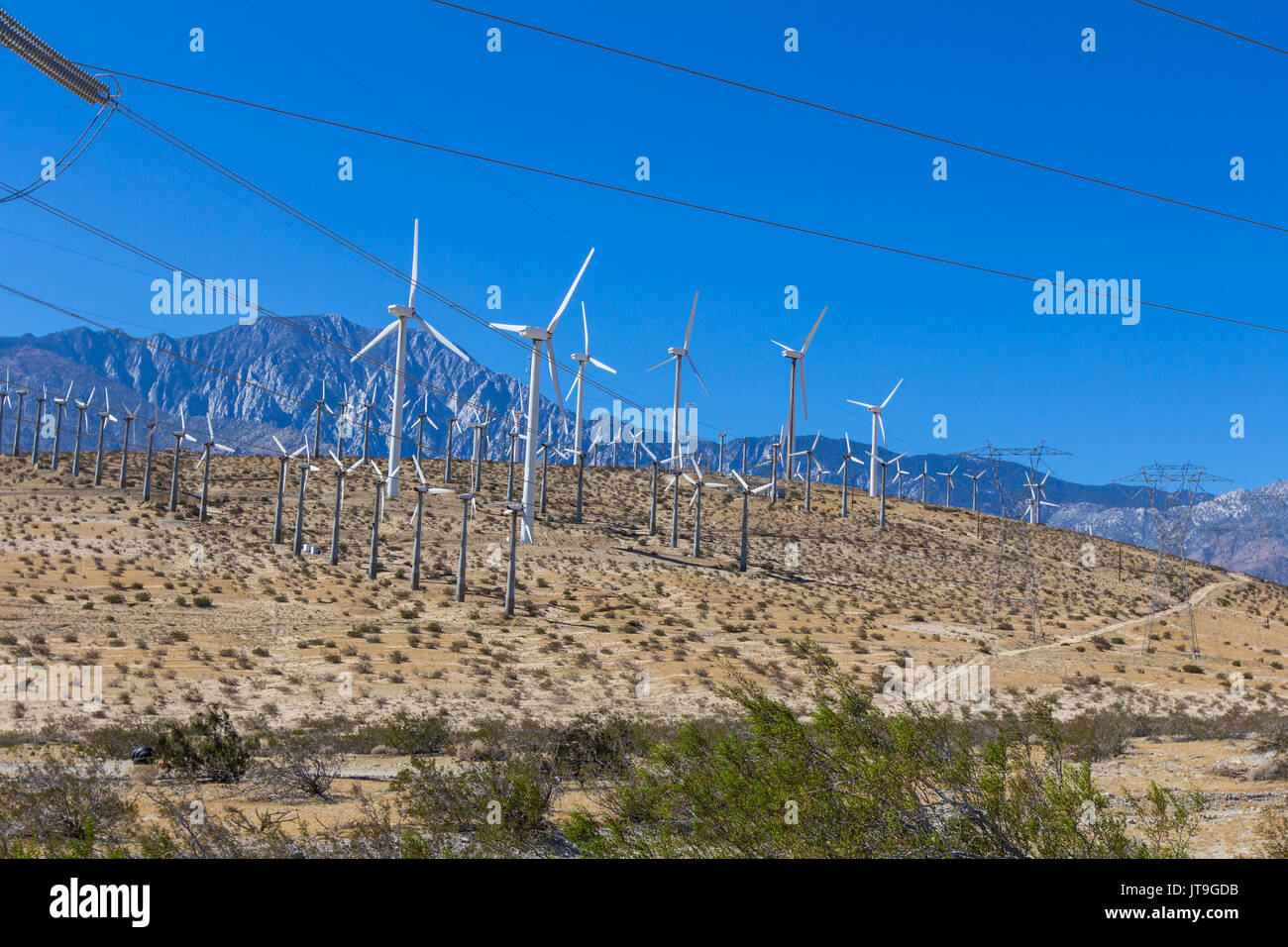 Wind turbine with power grid towers Stock Photo - Alamy