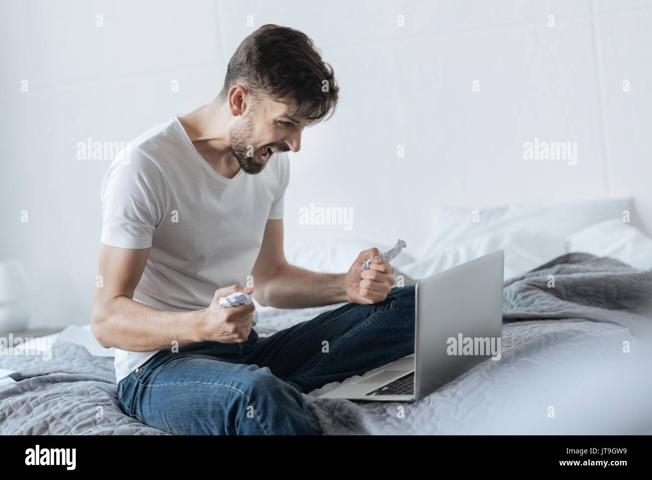 Cheerless angry man looking at the laptop screen Stock Photo - Alamy