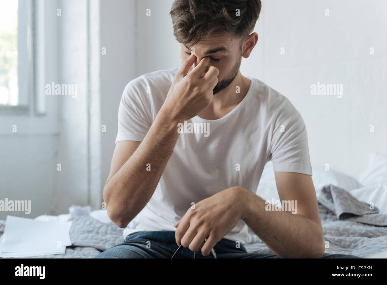 Sad moody man touching the bridge of the nose Stock Photo - Alamy