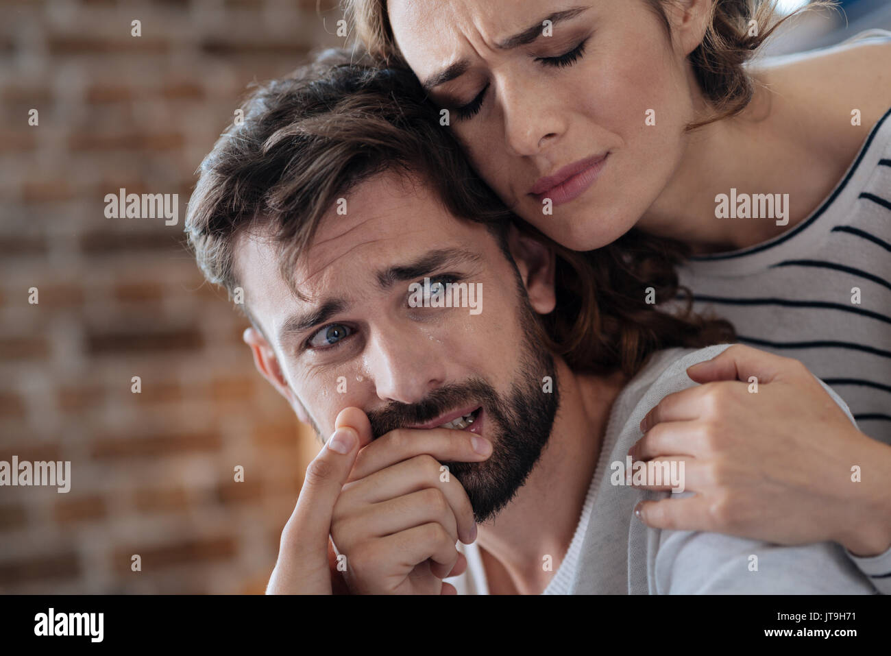 Unhappy crying man being consoled by his girlfriend Stock Photo - Alamy