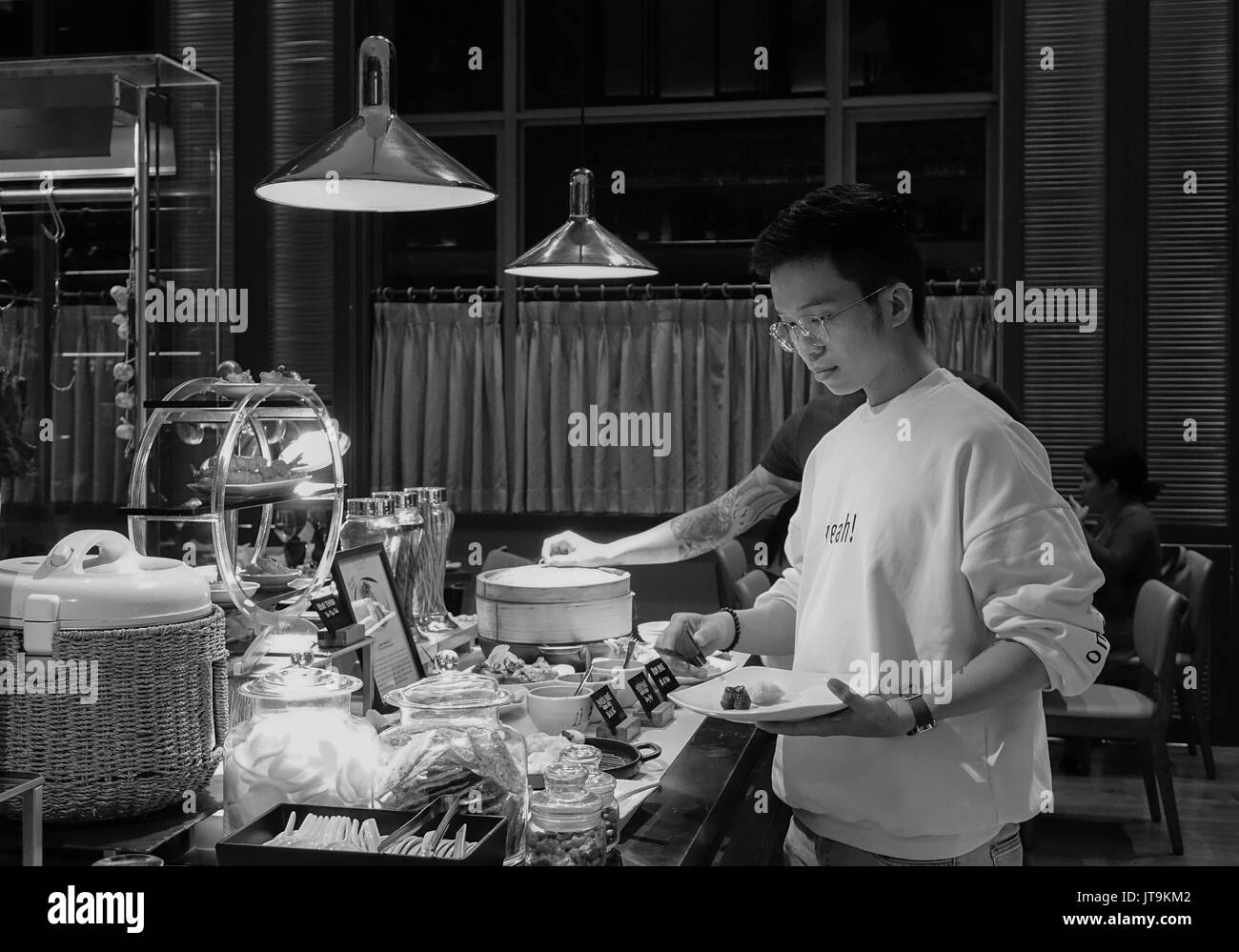 Saigon, Vietnam - May 26, 2017. A man taking food at the buffet ...
