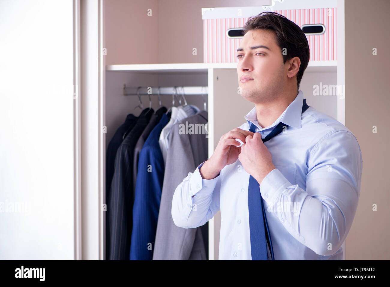 Young man businessman getting dressed for work Stock Photo - Alamy