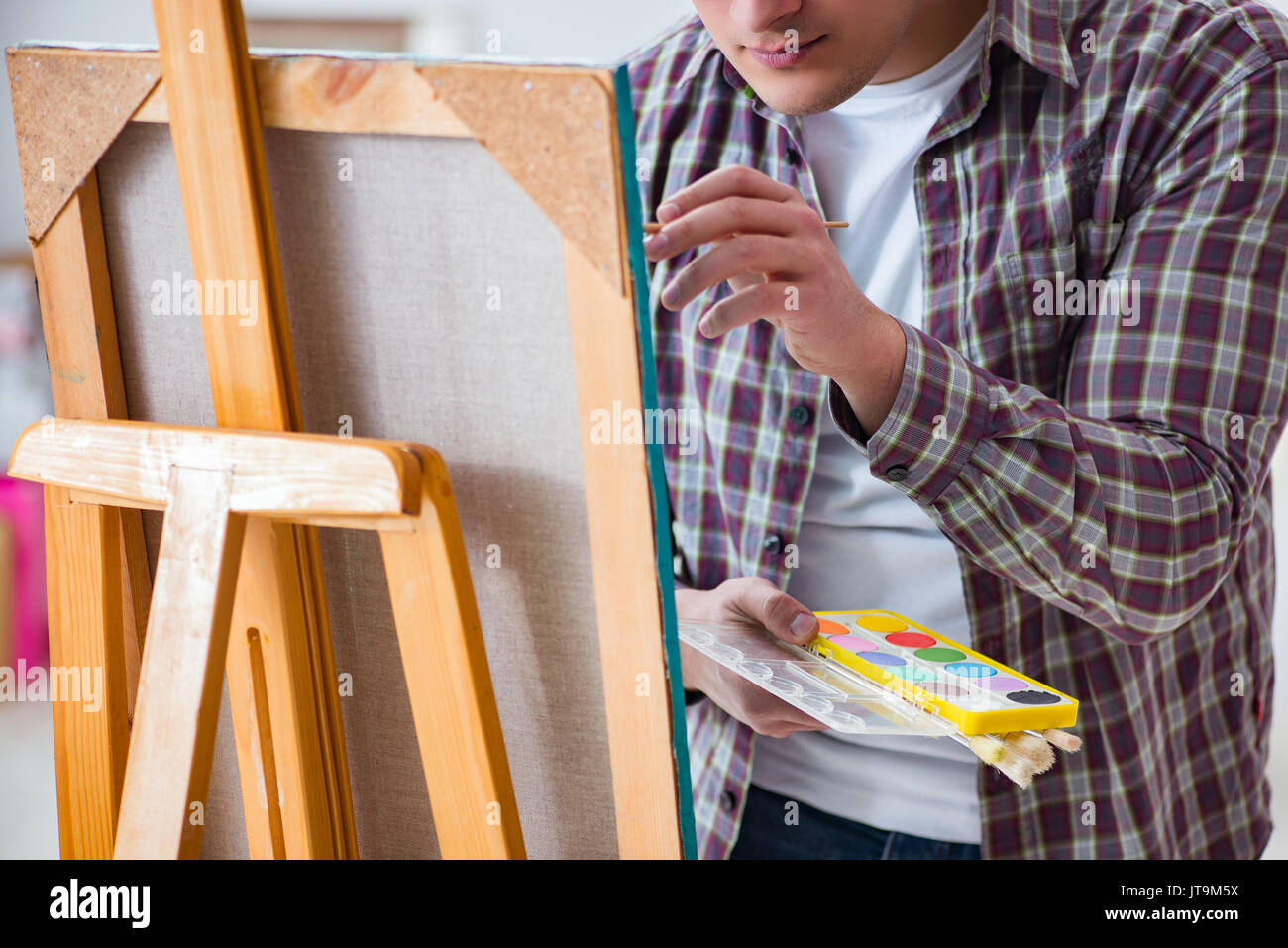 Young male artist drawing pictures in bright studio Stock Photo - Alamy