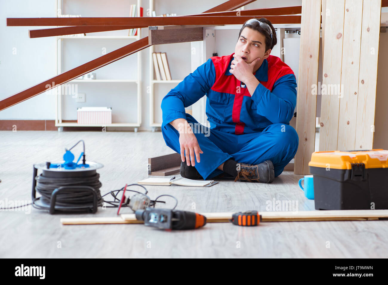 Young carpenter with notebook writing planning at construction repair ...