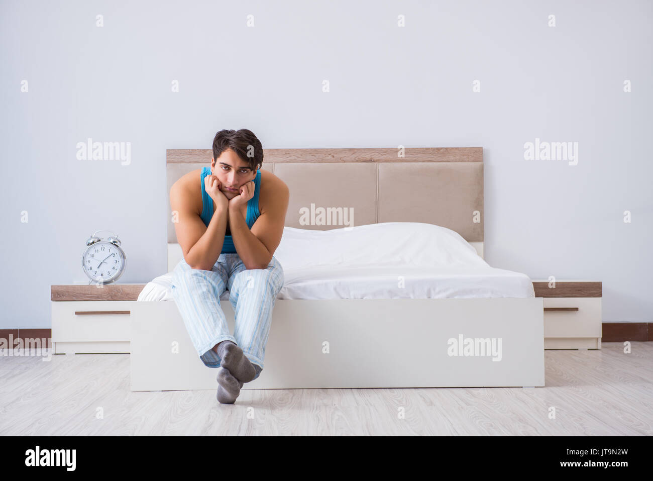 Young man waking up in bed Stock Photo - Alamy