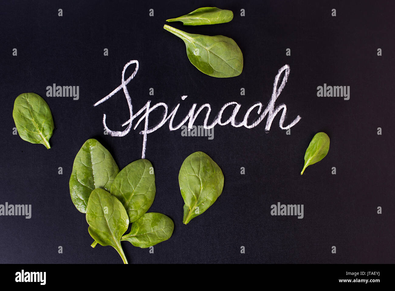 top view of fresh spinach leaves and lettering isolated on black Stock ...