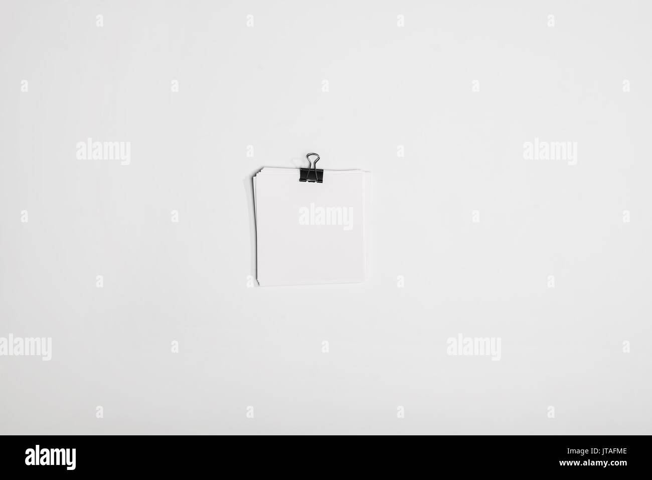top view of little stack of white note papers with binder clip isolated ...